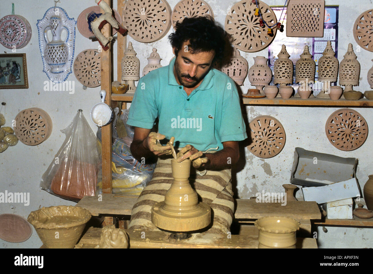 Potter throwing a pot in his studio surrounded by pottery objects Stock ...