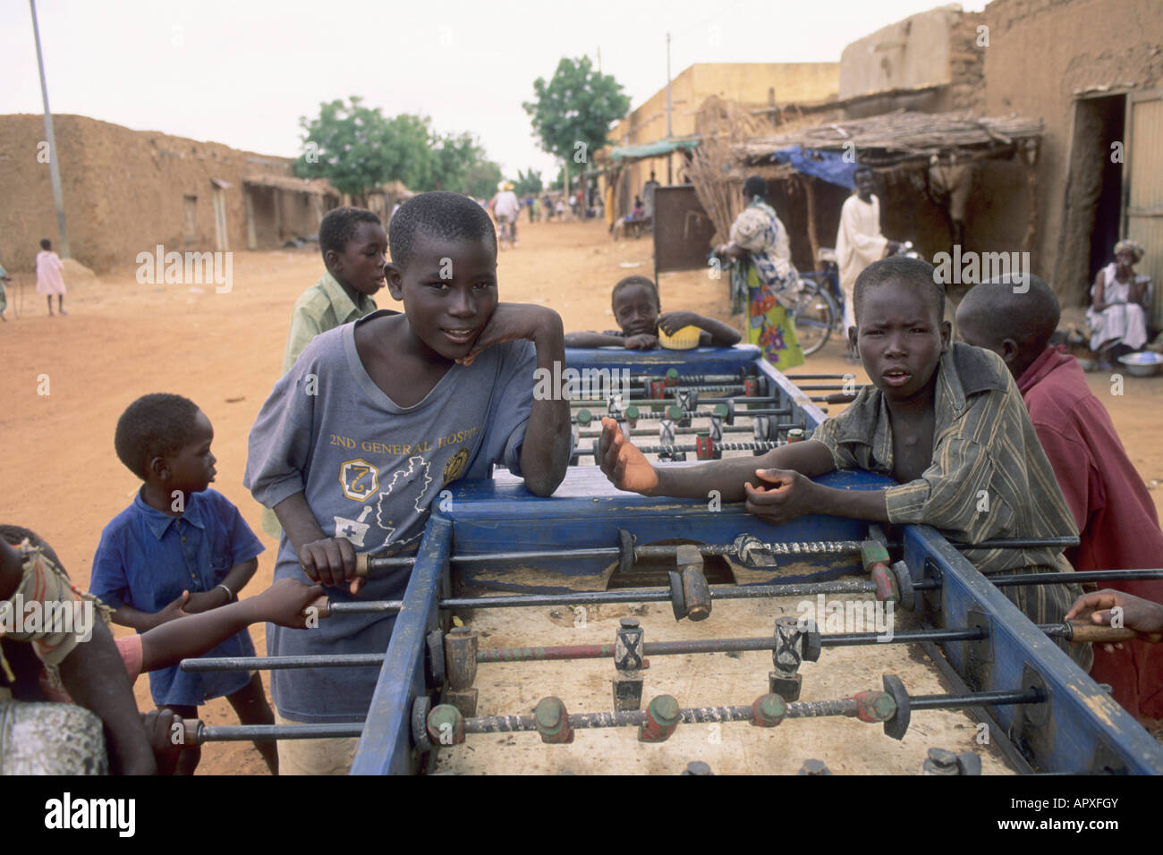 Children leaning on two dilapidated table soccer tables Stock Photo - Alamy
