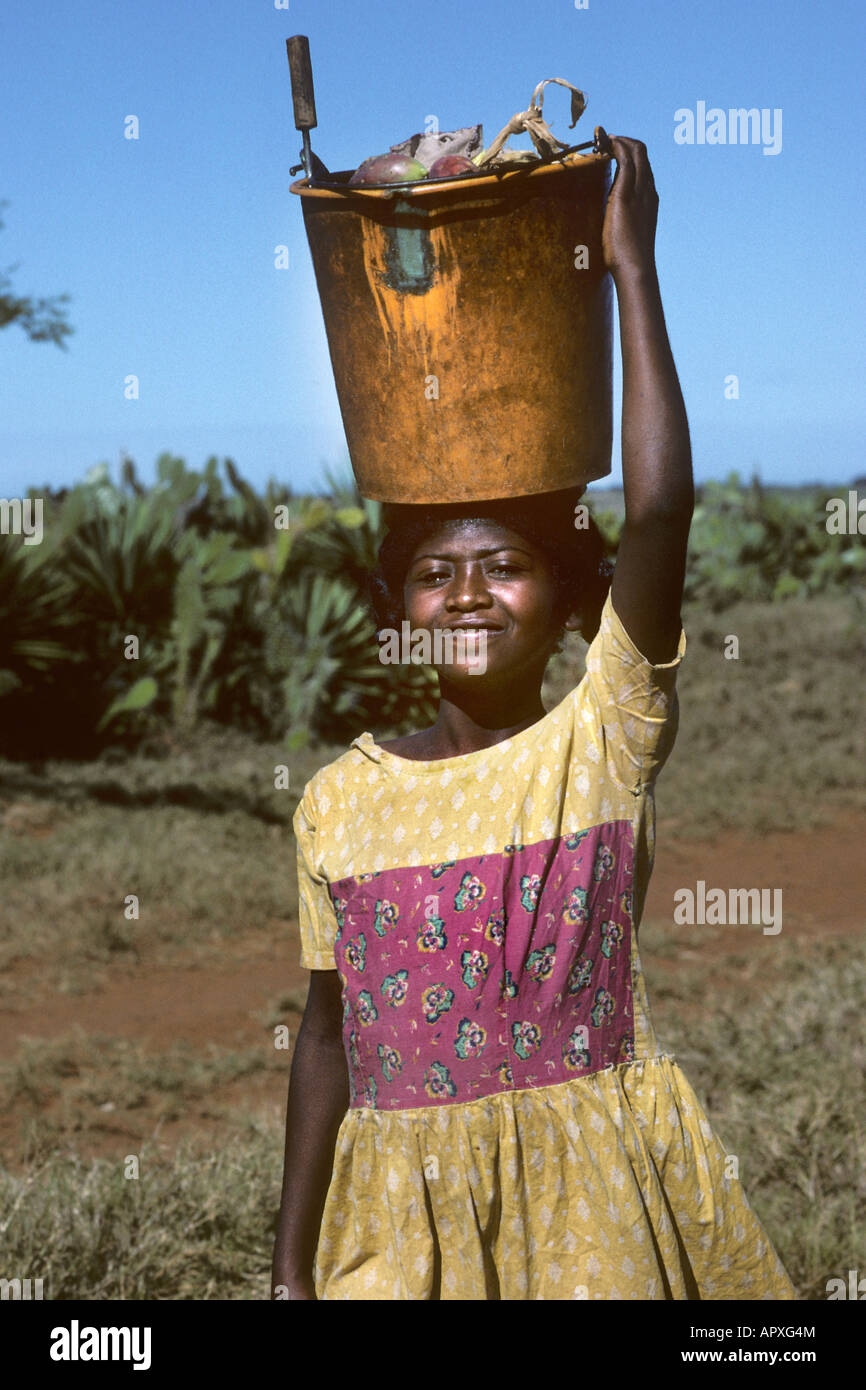 A young girl returning from the weekly market carrying a bucket on her ...