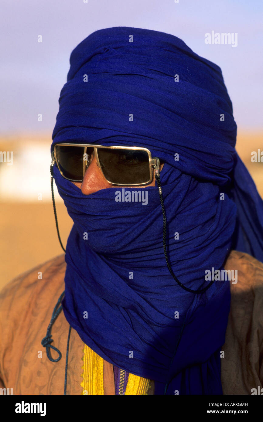 Portrait of a Tuareg man wearing a deep blue turban and sunglasses ...