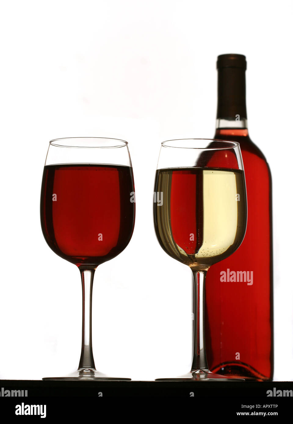 Glasses of red and white wine standing on table with red wine bottle ...