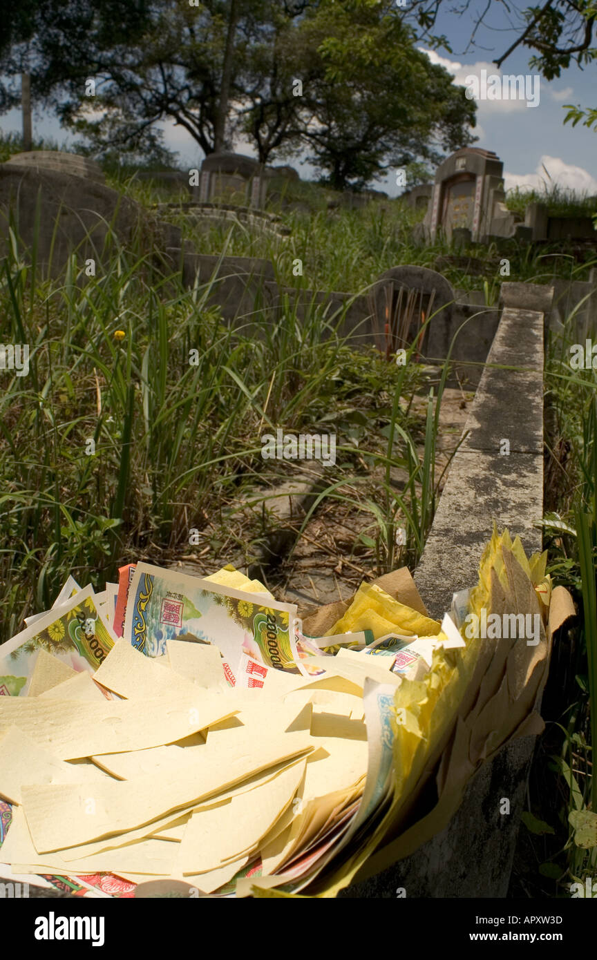 Hell money and josticks lying on a grave in a cemetery during the Qing ...