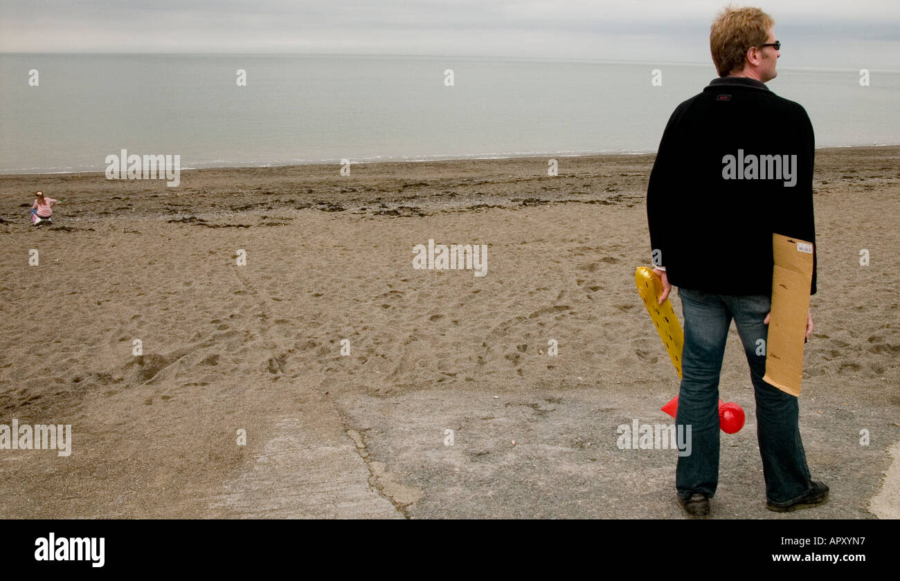 single man on aberystwyth promenade with inflatable plastic hammer ...