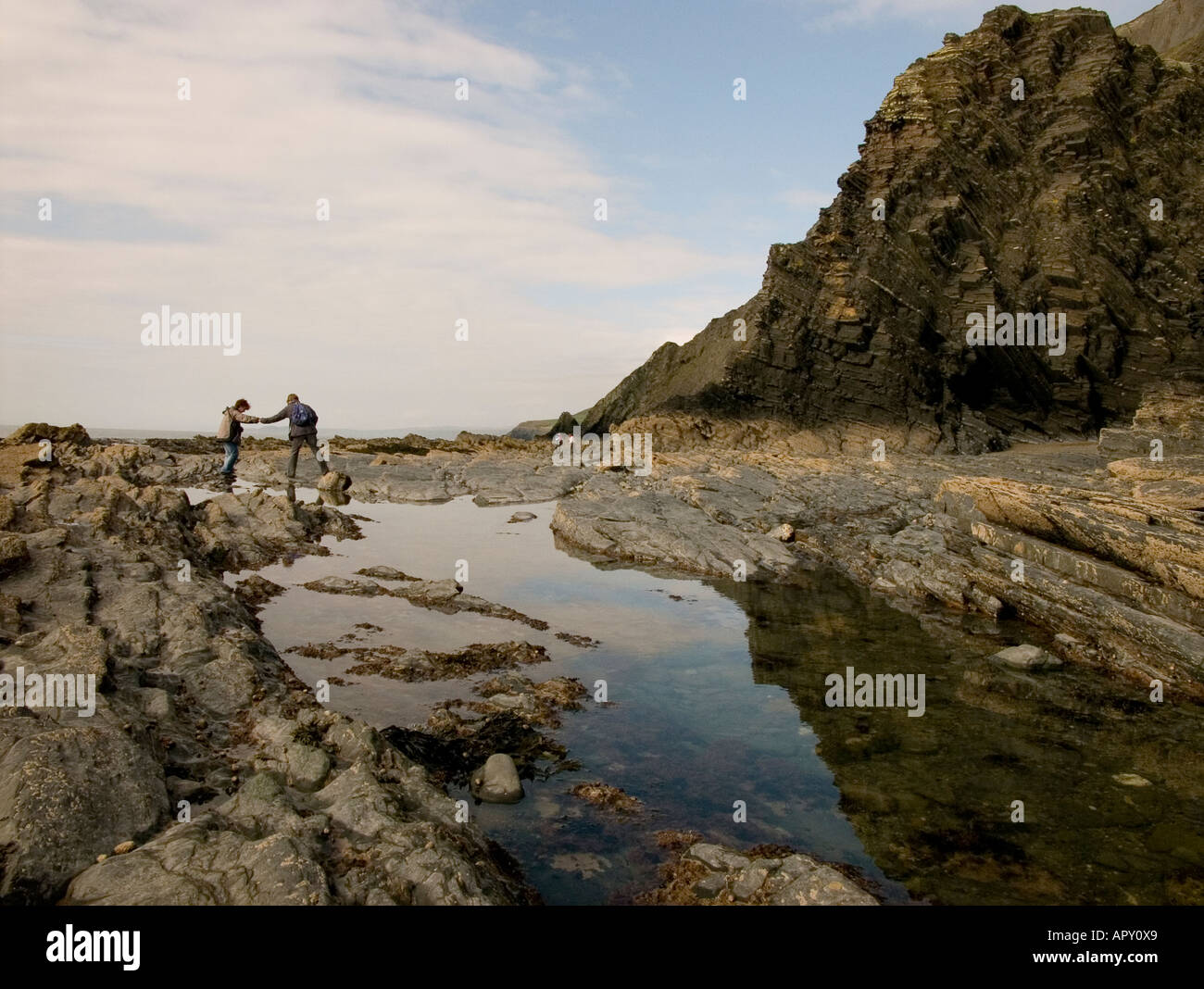 Two people walking on the rocks at the base of Constitution Hill Cliffs ...