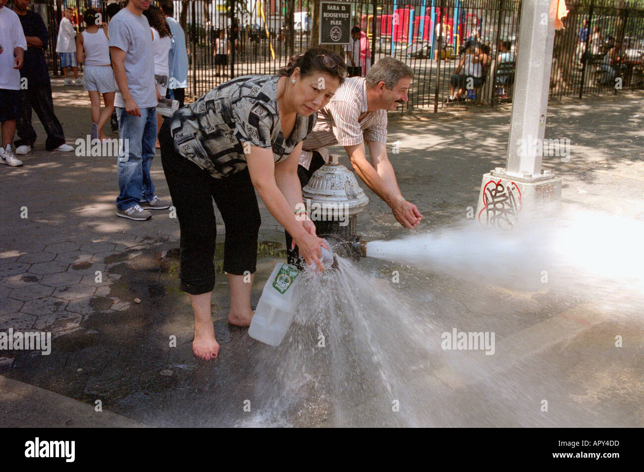 Women filling containers with escaping water from New York City fire ...