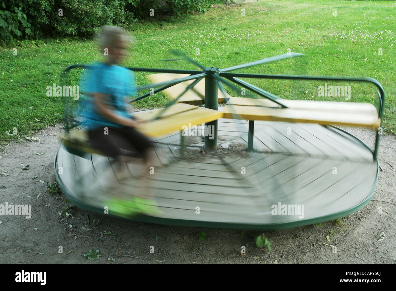 10 year old boy sitting in a spinning playground carousel Stock Photo ...