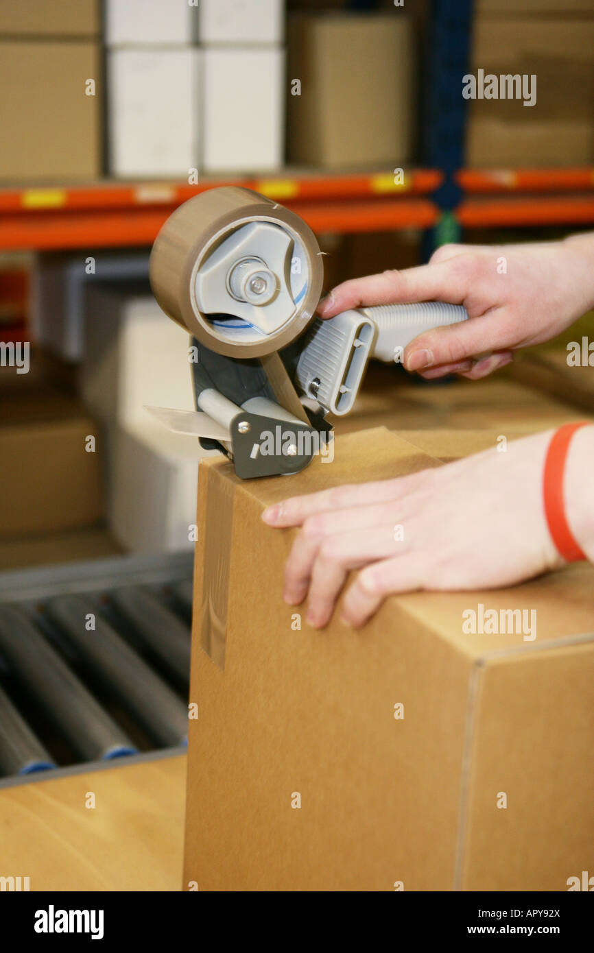 Worker taping box before posting Stock Photo - Alamy