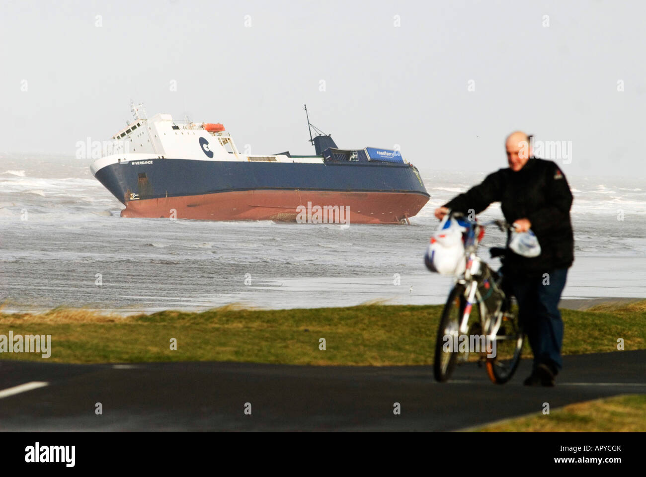 Man pushing bike past grounded ferry Riverdance on Cleveleys beach ...