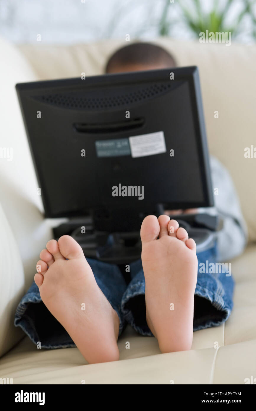 African boy using laptop on sofa Stock Photo - Alamy