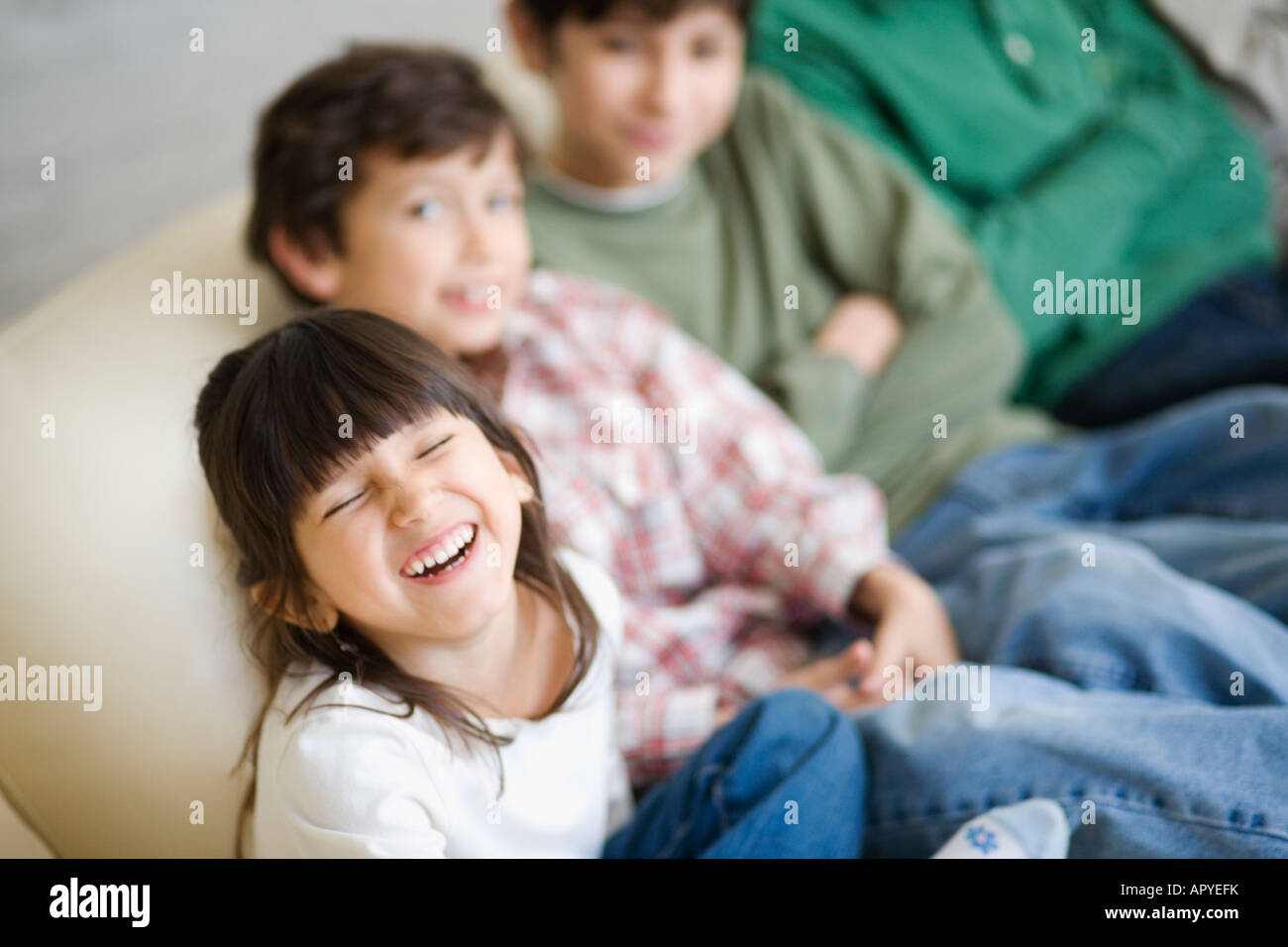 Hispanic siblings sitting on sofa Stock Photo - Alamy