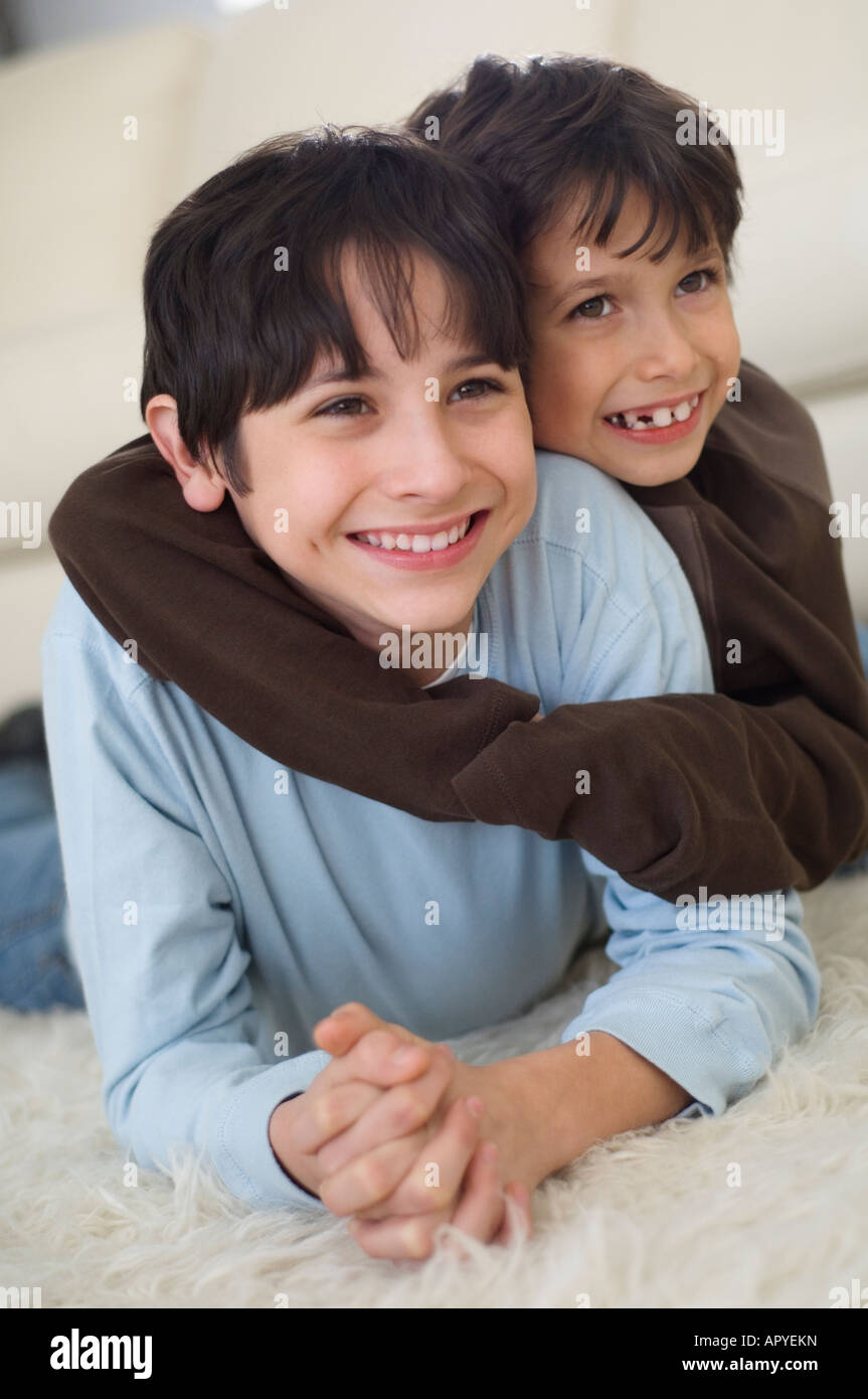 Hispanic brothers hugging on floor Stock Photo - Alamy