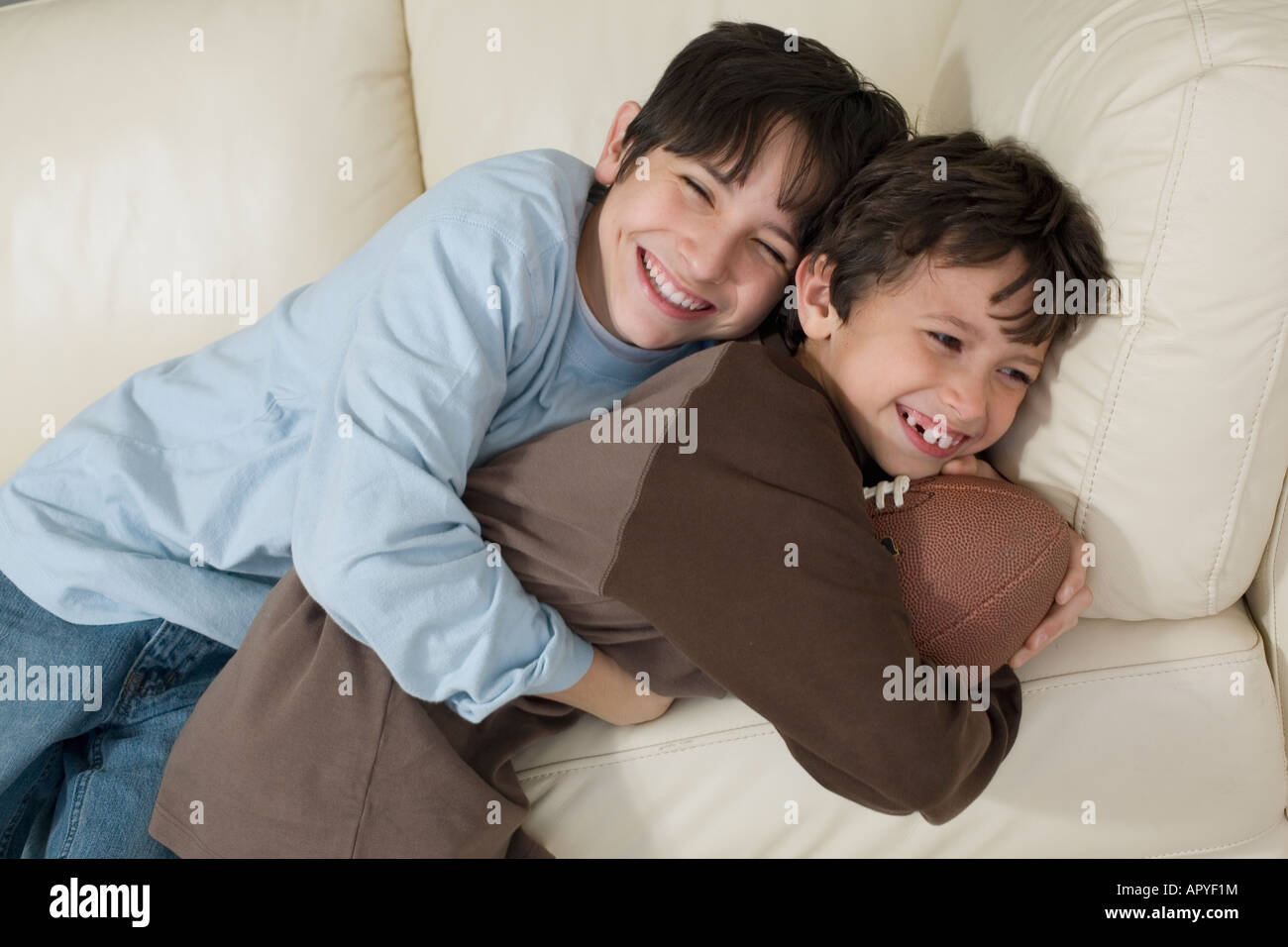 Hispanic brothers hugging with football Stock Photo - Alamy
