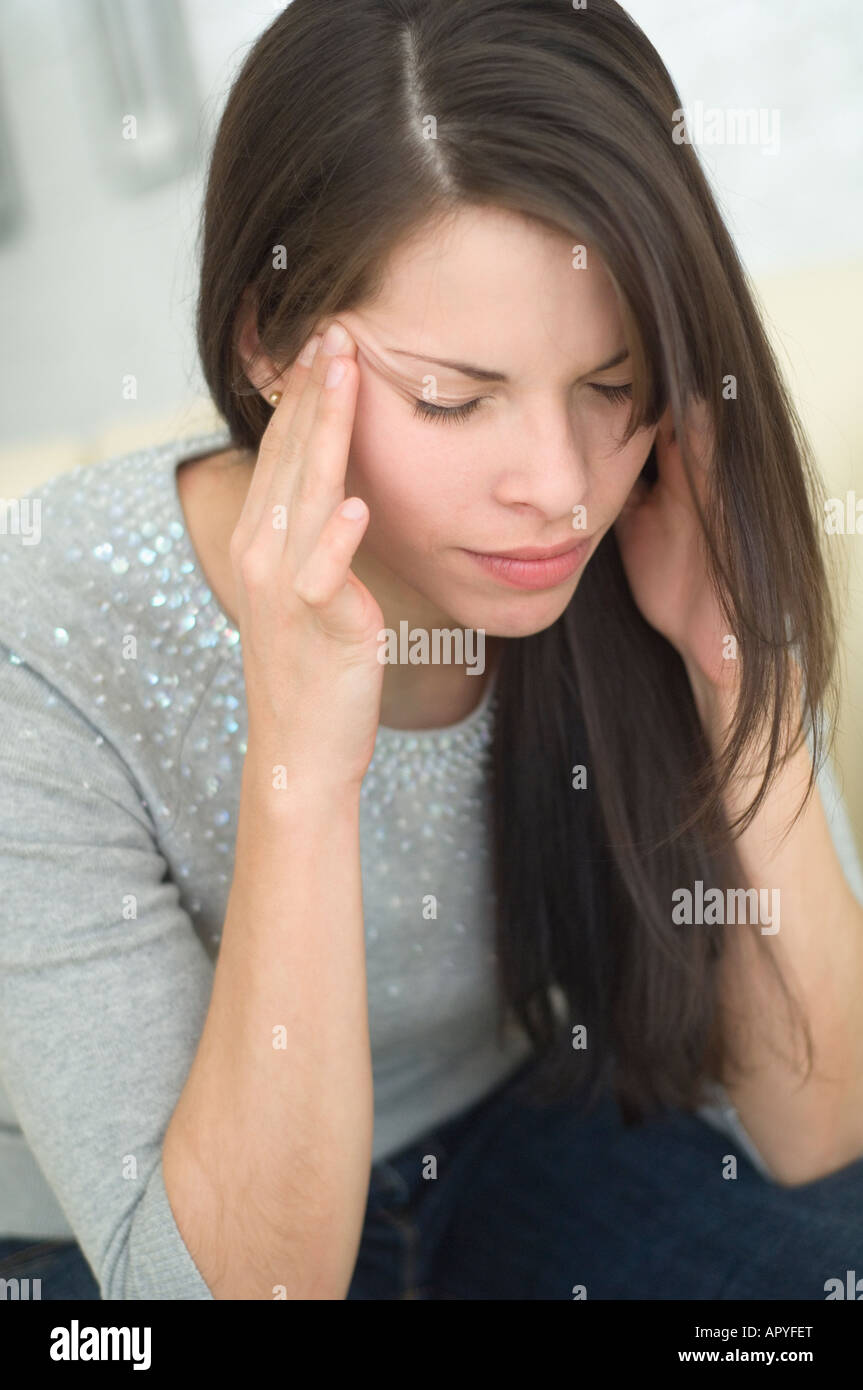 Hispanic woman rubbing head Stock Photo - Alamy
