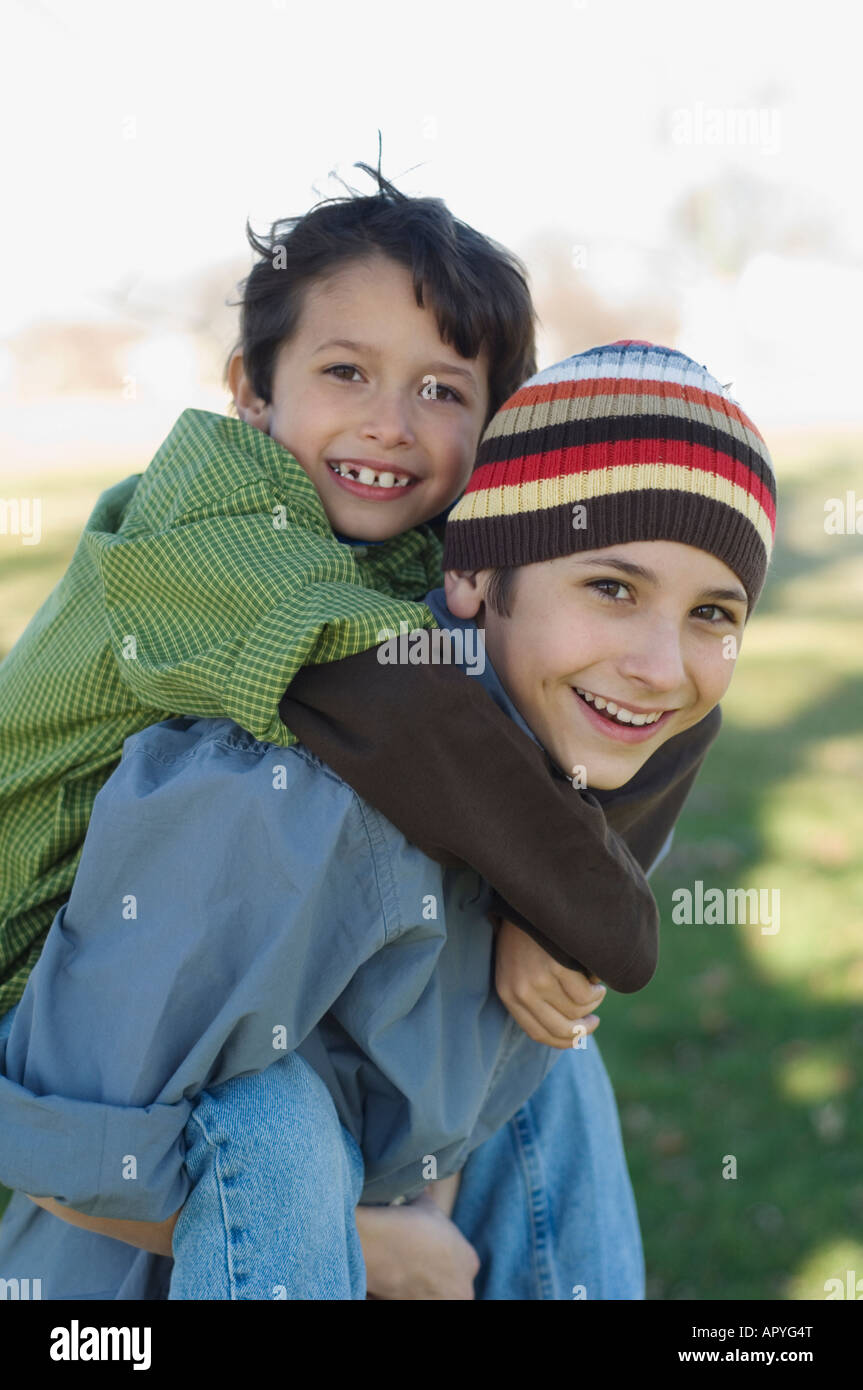 Boy giving brother piggyback hi-res stock photography and images - Alamy
