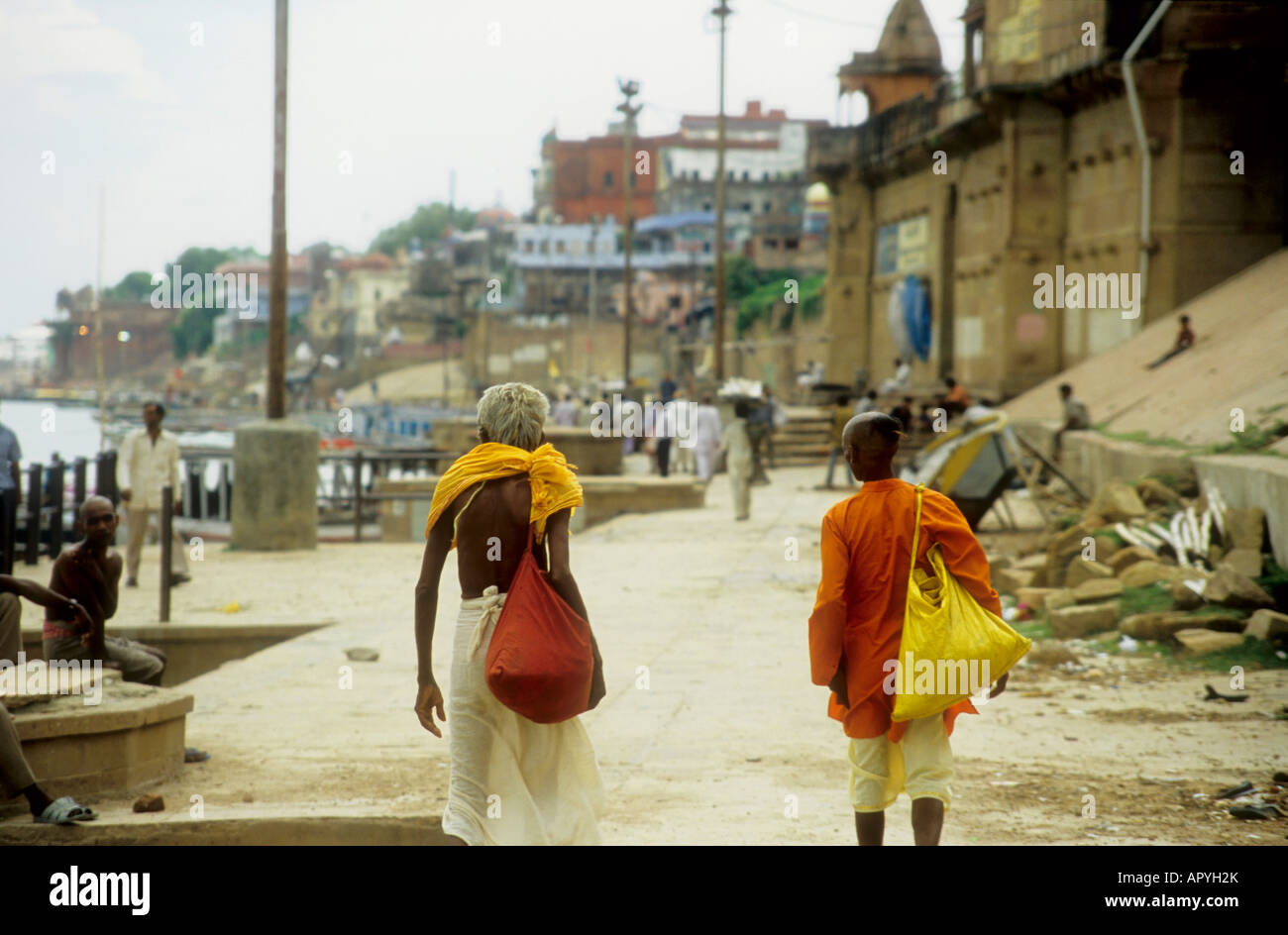 Sadhu men walking by the ghats on the banks of the Ganges in Varanasi ...