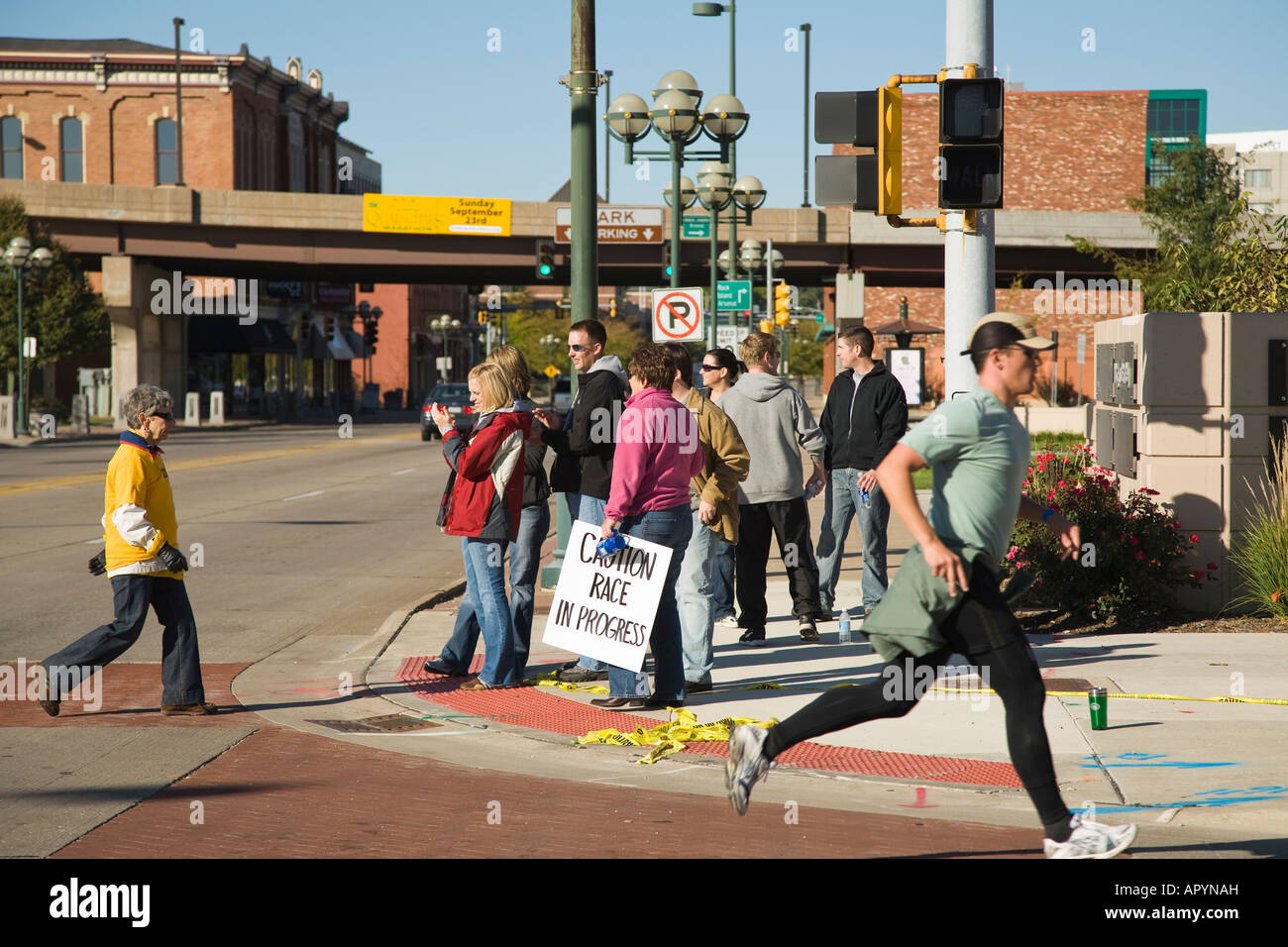 ILLINOIS Moline Male runner in race passing group of people standing on ...
