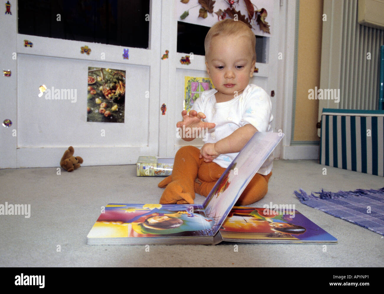 Boy one years old reading children book Stock Photo - Alamy