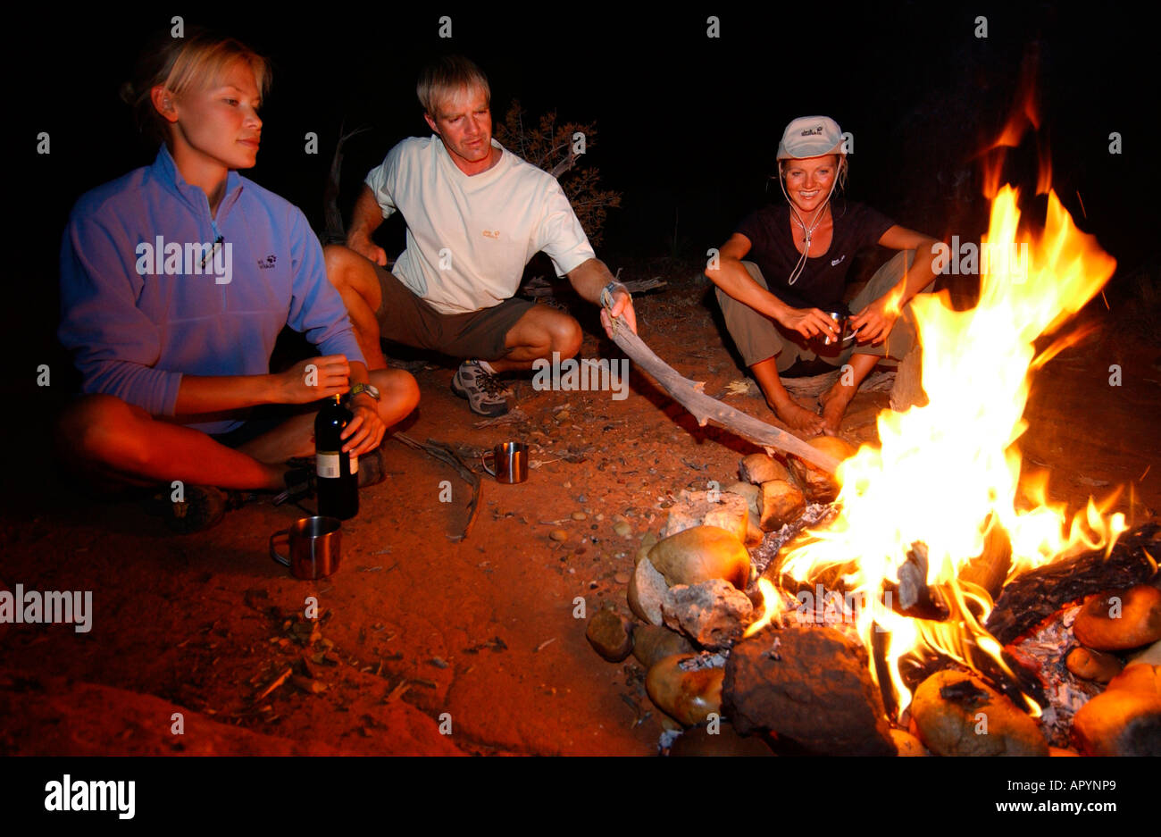 Three people sat around a campfire, Camping, Arizona, USA Stock Photo ...