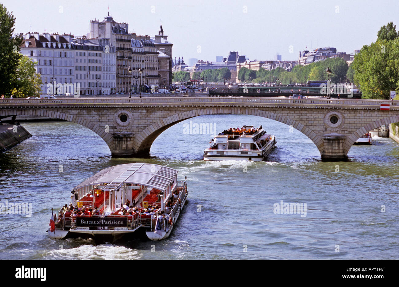 Paris Ile de La Cite tourist boats under bridge at dusk Stock Photo - Alamy