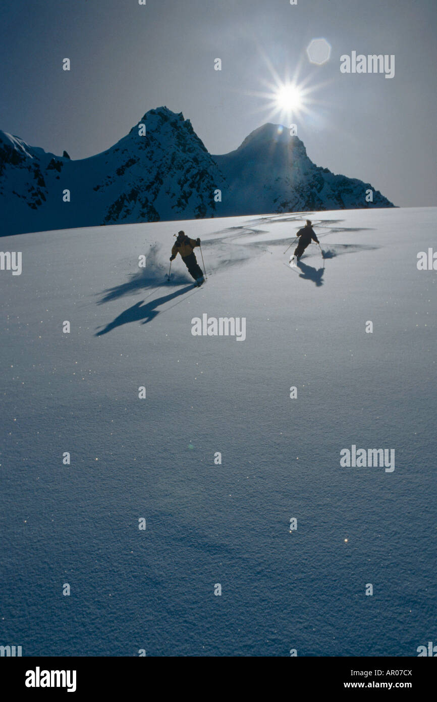 Downhill skiers in powder snow sunburst Alaska Stock Photo - Alamy