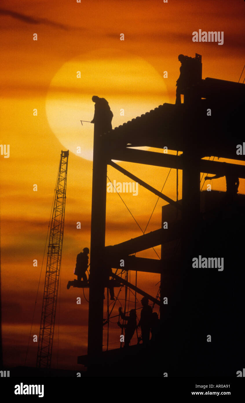 High steel construction workers silhouetted at sunset Stock Photo - Alamy