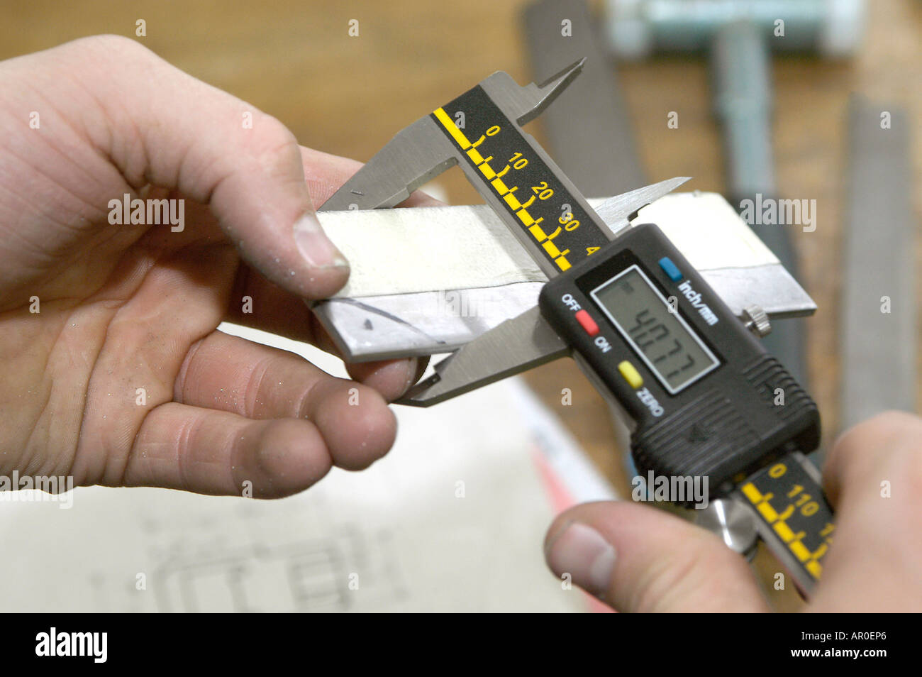 Apprenticeship training - measuring a work pice with a sliding calliper ...