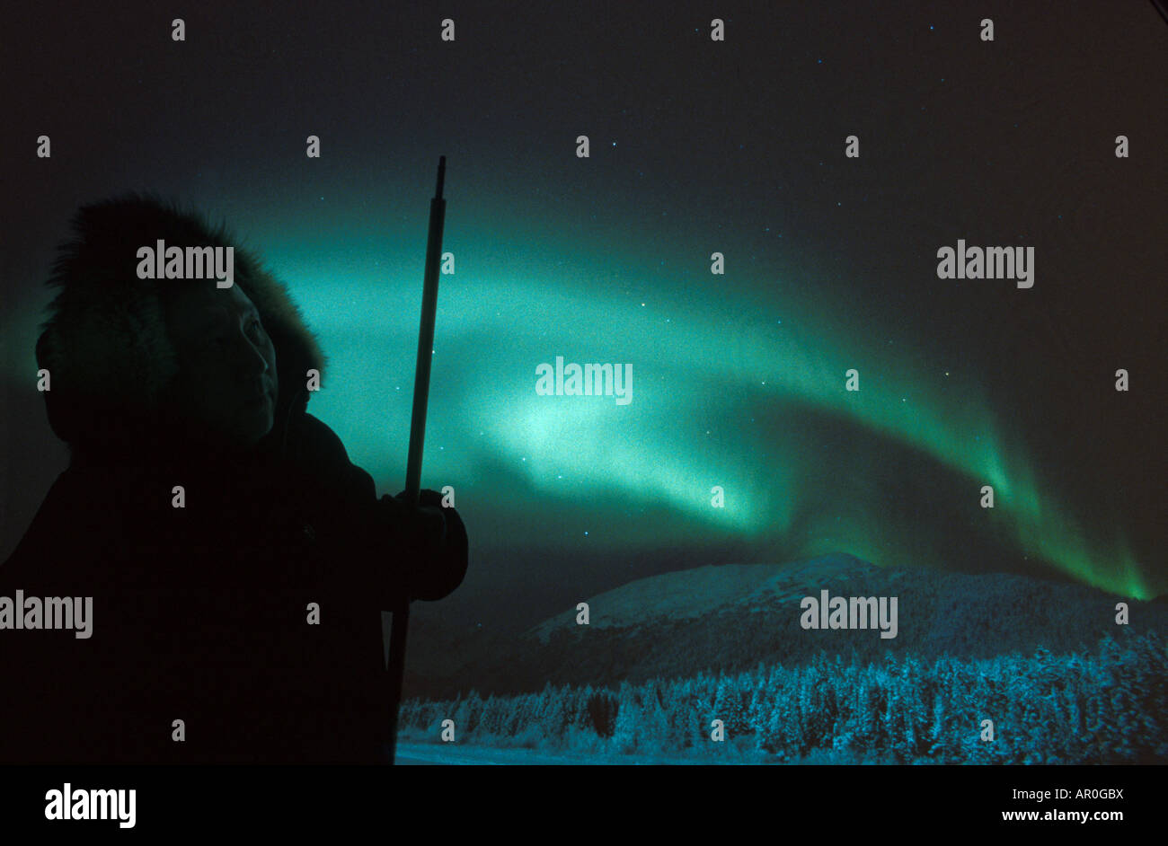 Eskimo man viewing Northern Lights over Mt Range Alaska composite ...