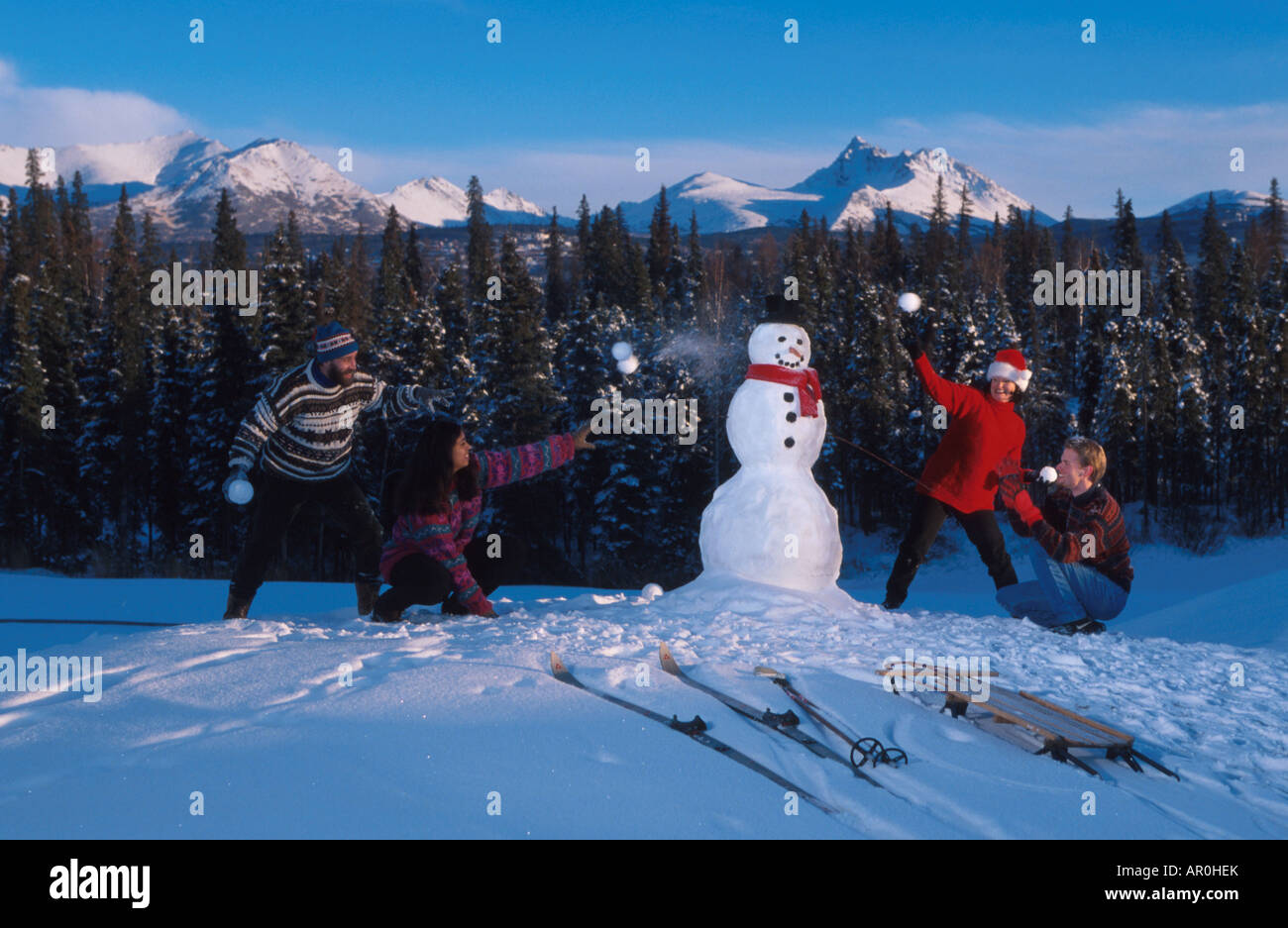 Group of Adults Having Snowball Fight with Snowman Winter SC Alaksa ...