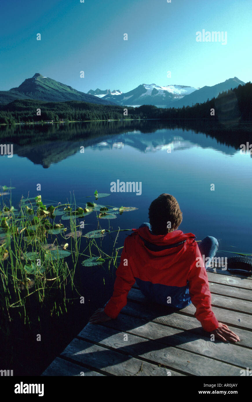 Man on dock Auke Lake Juneau Coast Mtns Southeast Alaska summer viewing ...