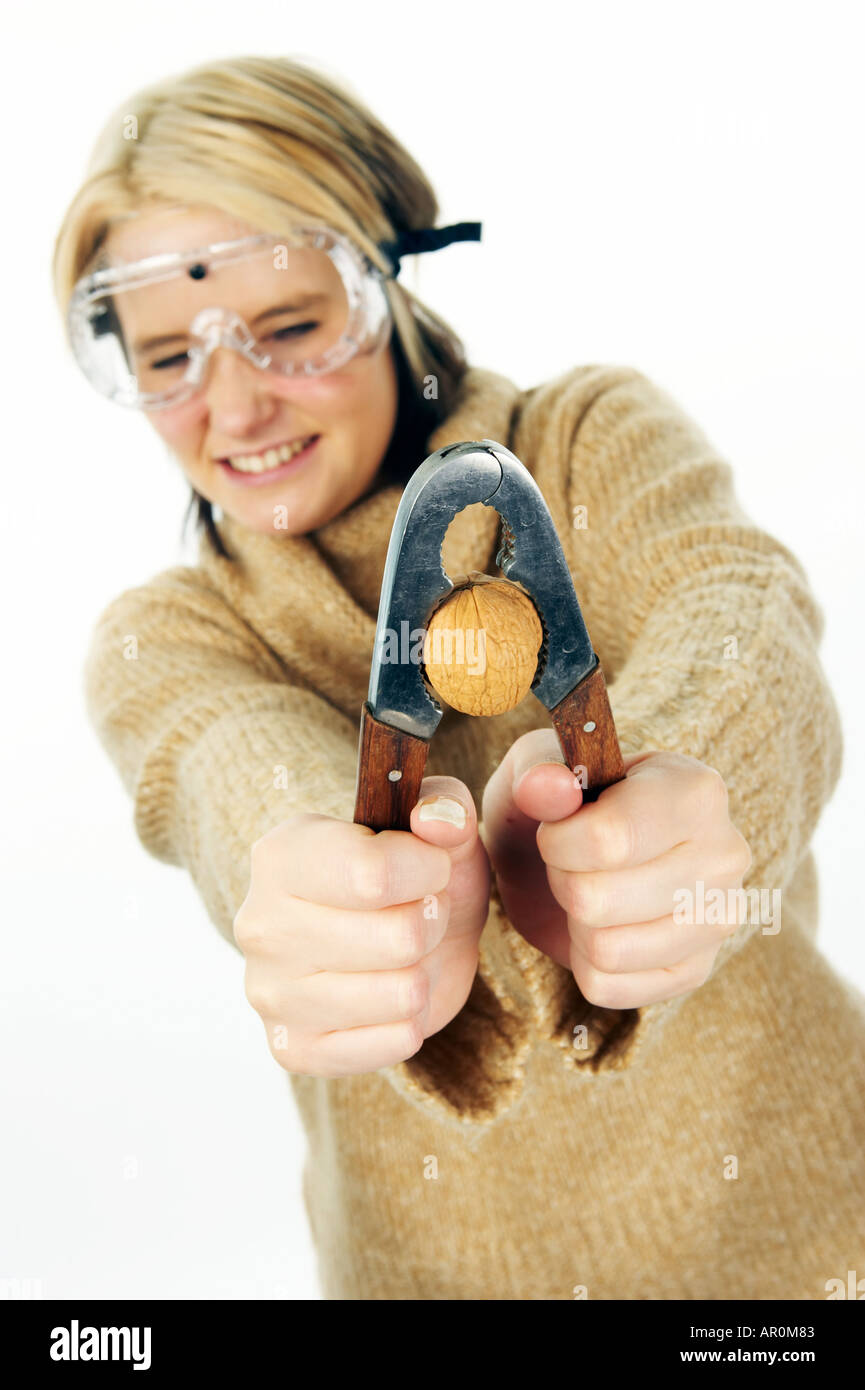 Young woman cracking tough walnut Stock Photo - Alamy