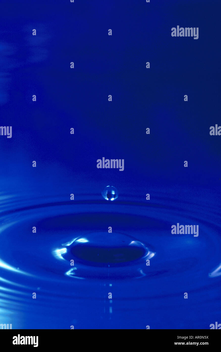 Water drop dropping in pool detail / blue Stock Photo - Alamy