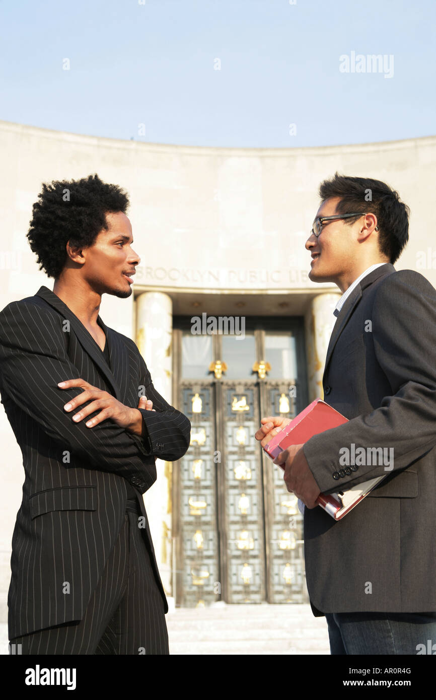 Two men standing face to face talking Stock Photo - Alamy
