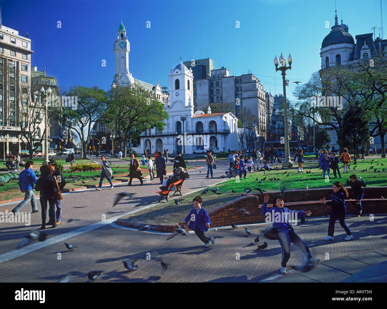 The Cabildo and Clock Tower above playful children and pigeons at Plaza ...