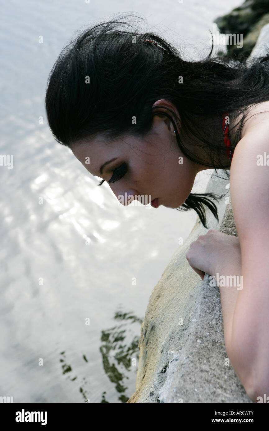 Woman leaning over, looking at water Stock Photo - Alamy