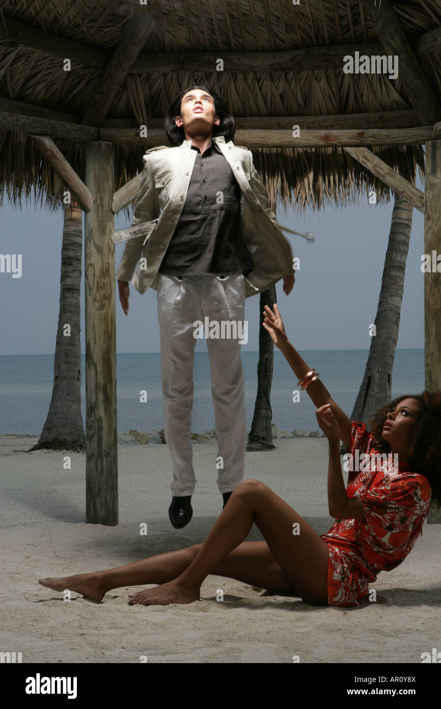 Young man floating towards the light with woman reaching Stock Photo ...
