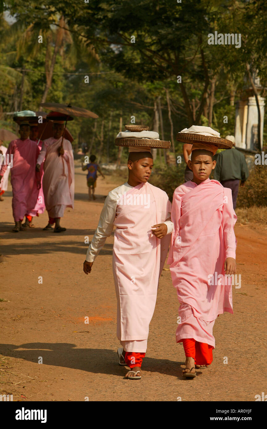 Nuns walk in a line to collect alms, Bago, Nonnen in rosa Roben, gehen ...
