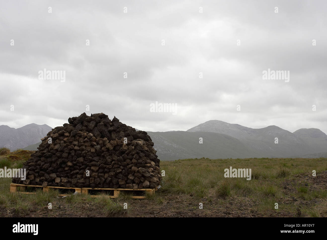 mound of Turf peat cut in a peat bog in front of mountains in Connemara ...
