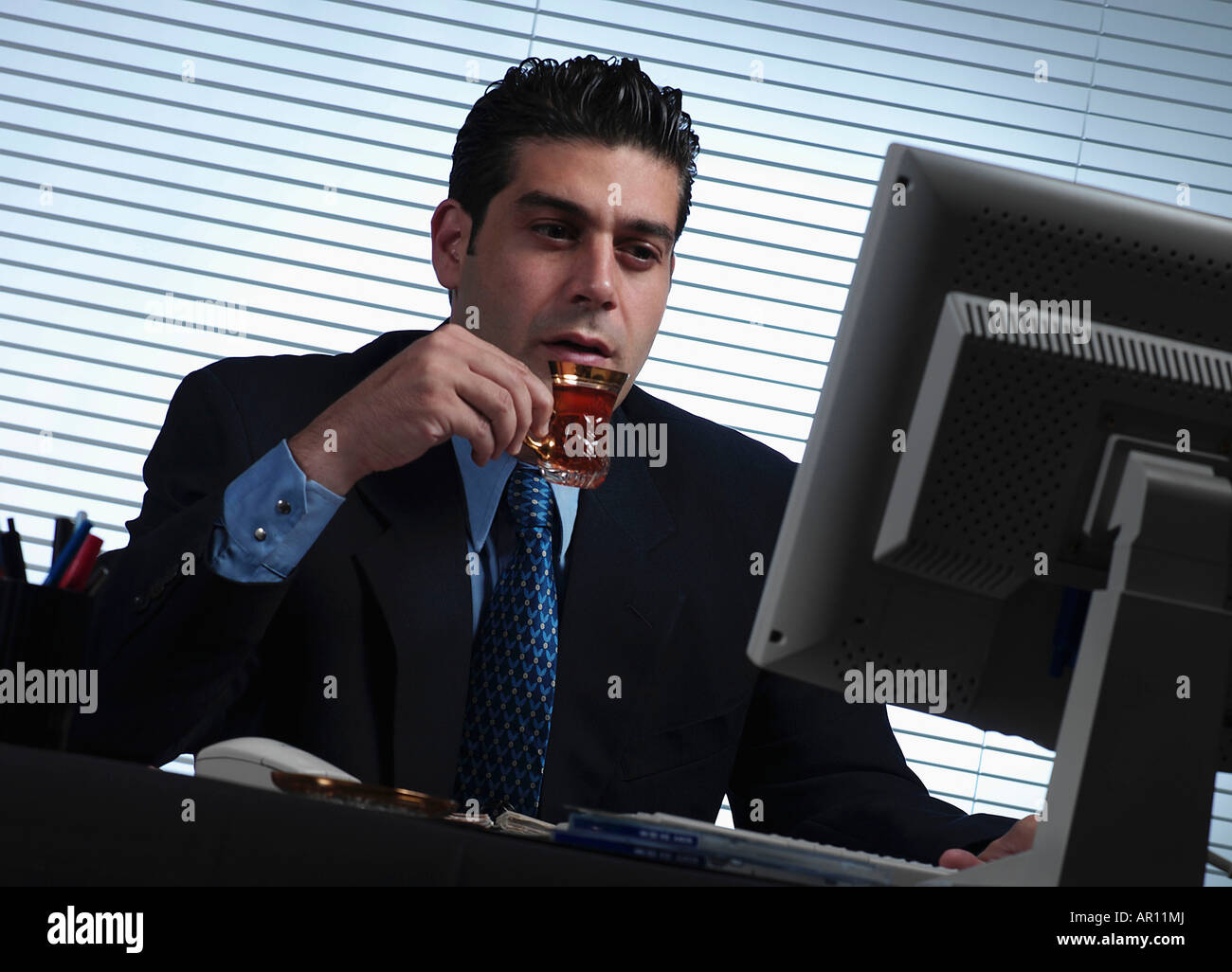 Businessman having his tea in office Stock Photo - Alamy