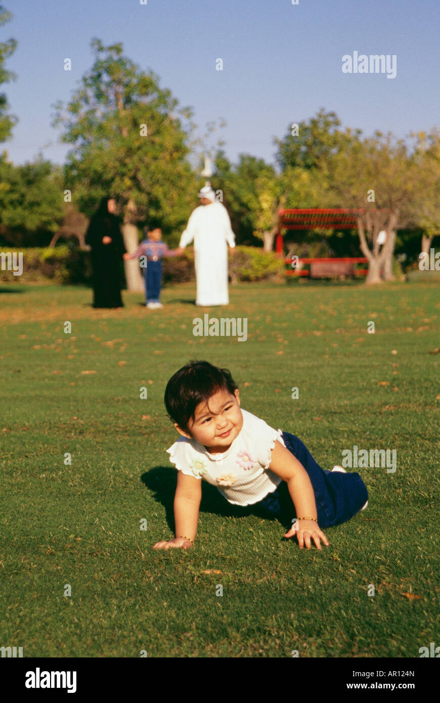 A baby smiles while crawling on the ground Stock Photo - Alamy
