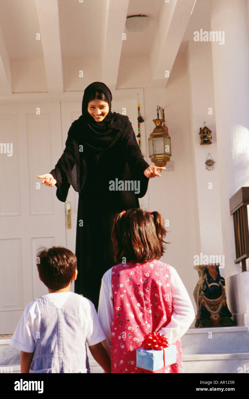 A mother calling her children affectionately as daughter hides the gift ...