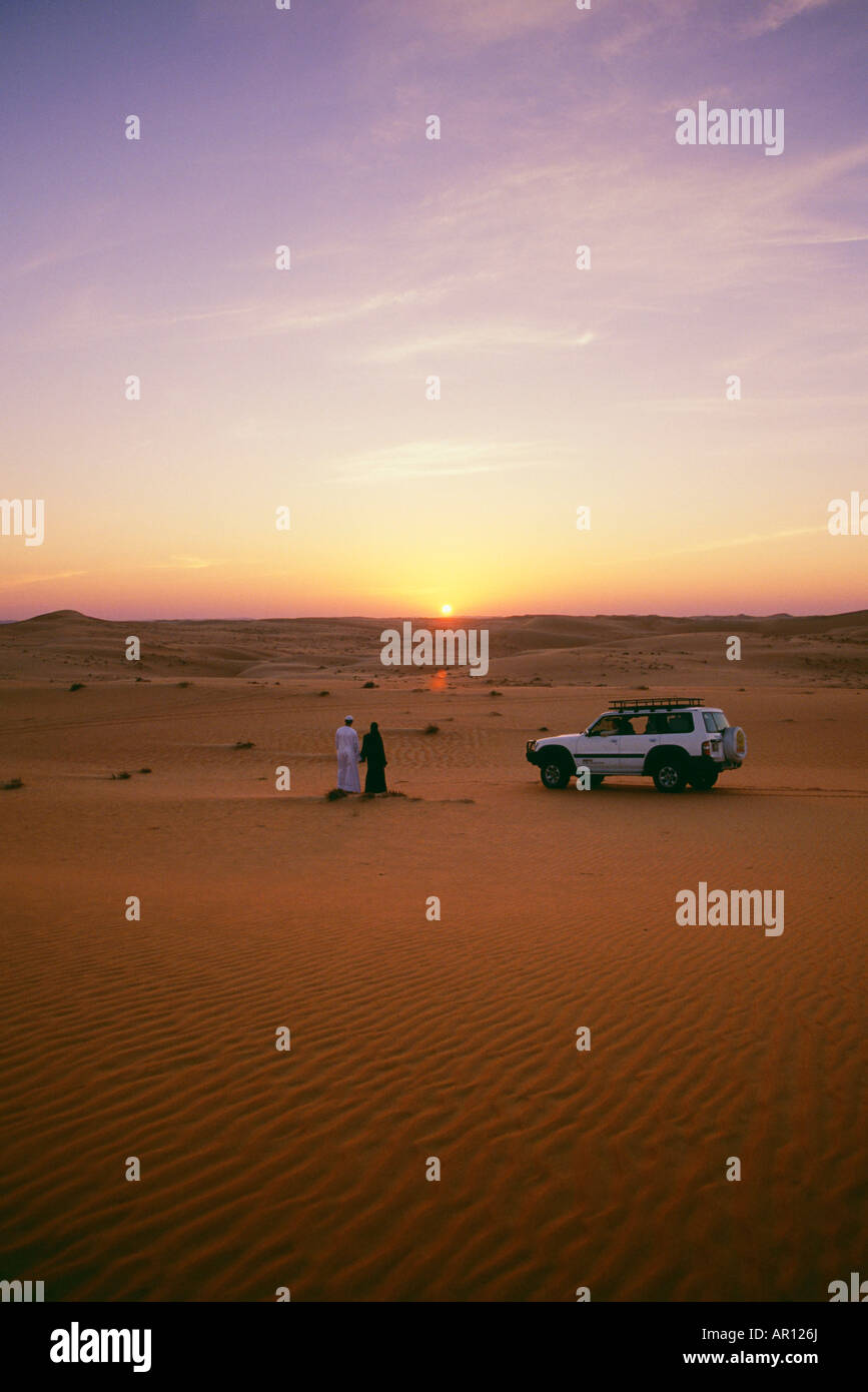 A couple viewing the sunset from the desert Stock Photo - Alamy