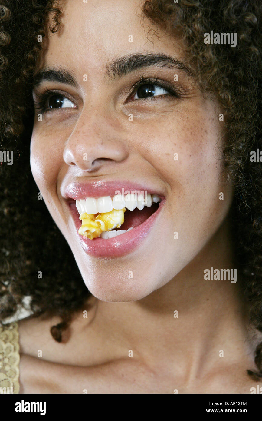 Woman smiling with popcorn between her teeth Stock Photo - Alamy