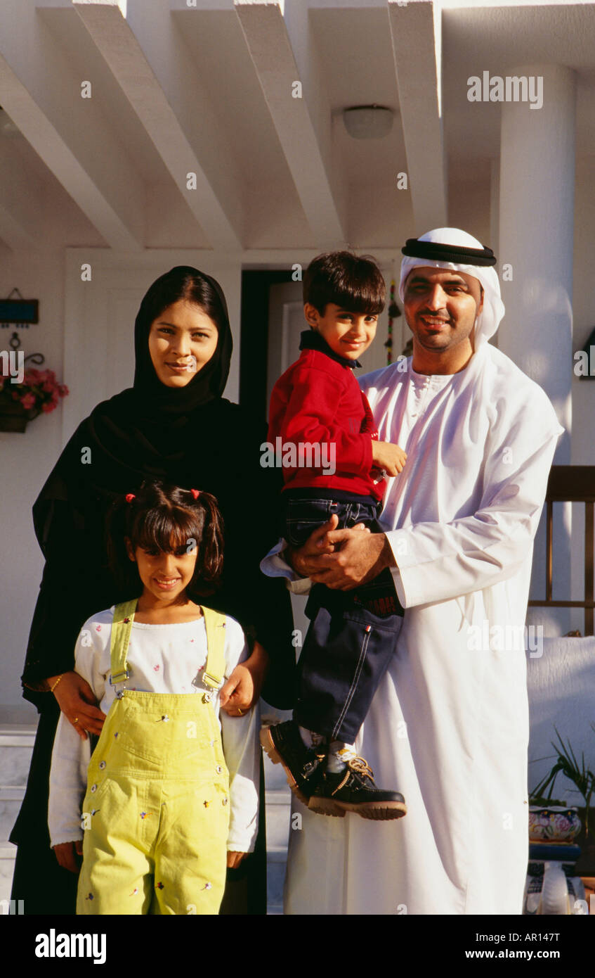 An Arab family stands outside their house and pose in front of the ...