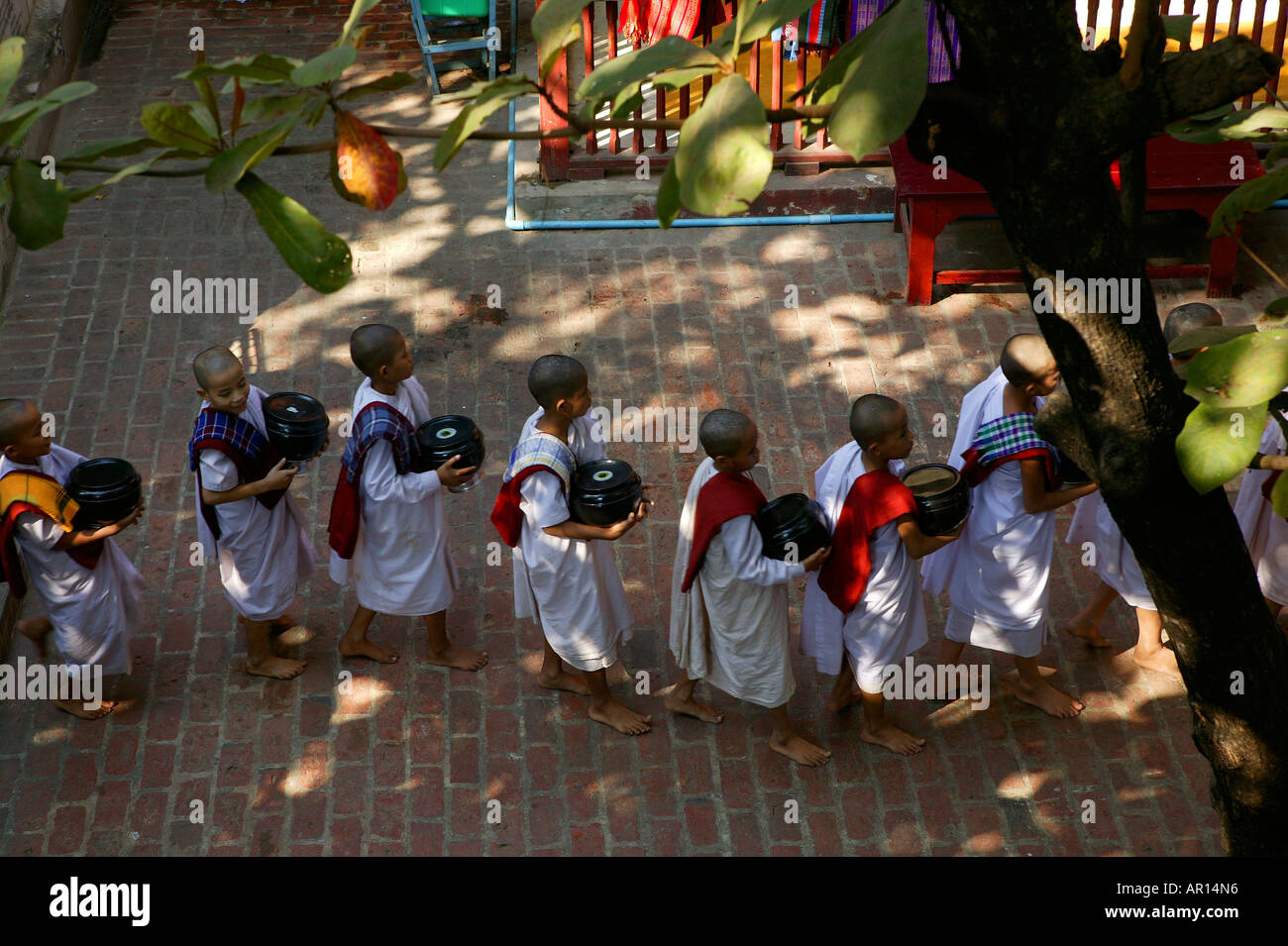 line of young nuns going into the dining hall of monastery, Myanmar ...