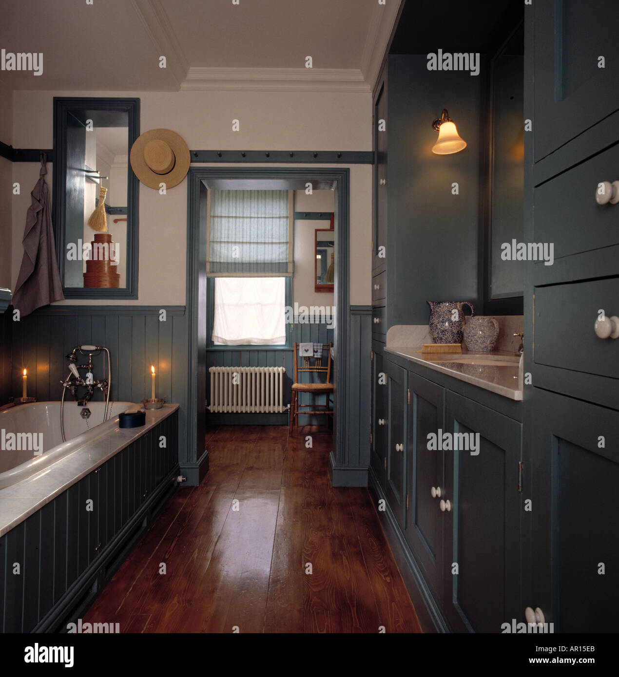 Polished wooden floor in panelled green Shaker style bathroom Stock ...