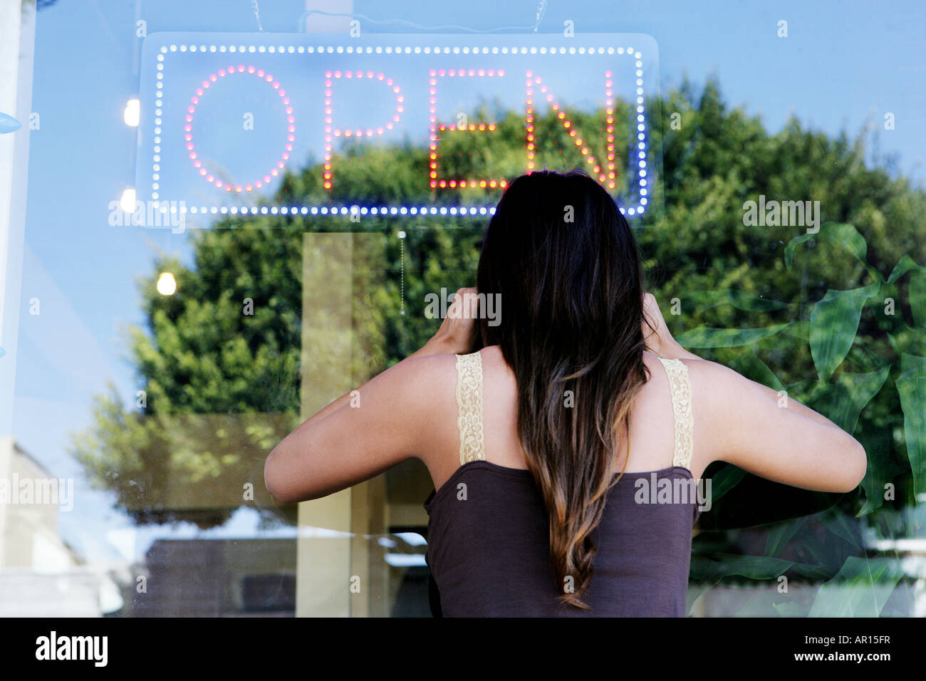 Back view of a woman looking in a window Stock Photo - Alamy