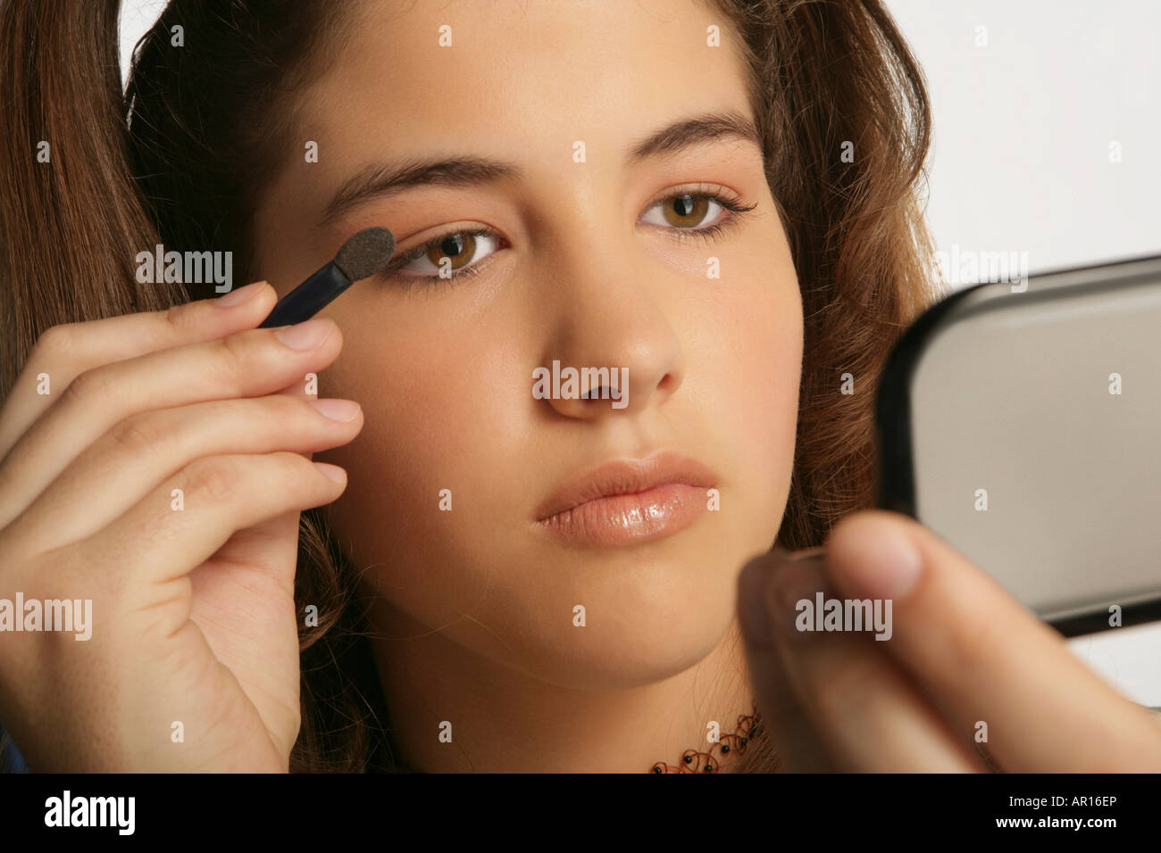 Young girl applying make-up on her face Stock Photo - Alamy