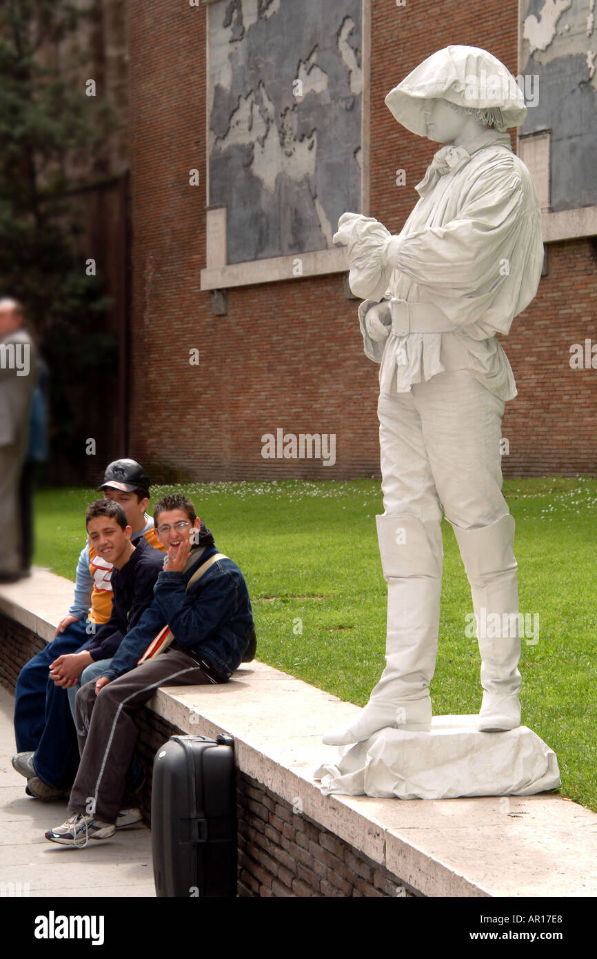 Tourist look at white painted mime posing as a statue act Colosseum ...