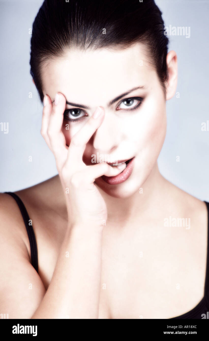 indoor studio close up woman 25 30 young brunette smile smiling strap straps hand touch face ...