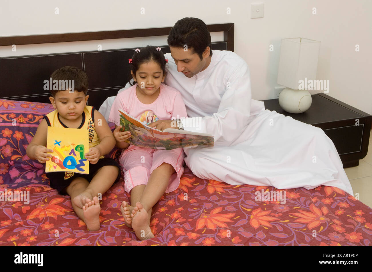 Father helping children read in the bedroom Stock Photo - Alamy
